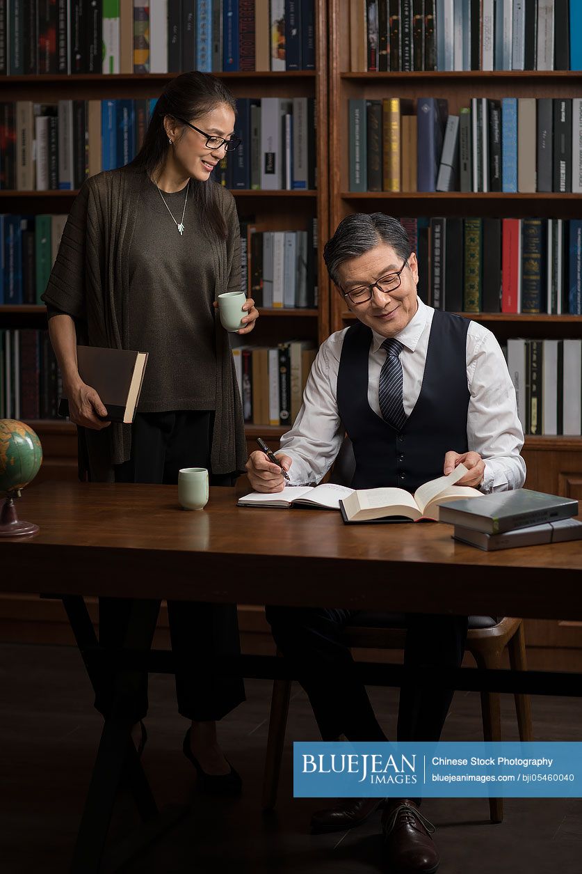 Mature Chinese couple reading books in study-High-res stock photo for ...