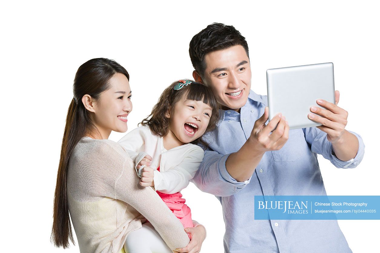 Happy young Chinese family using digital tablet-High-res stock photo ...