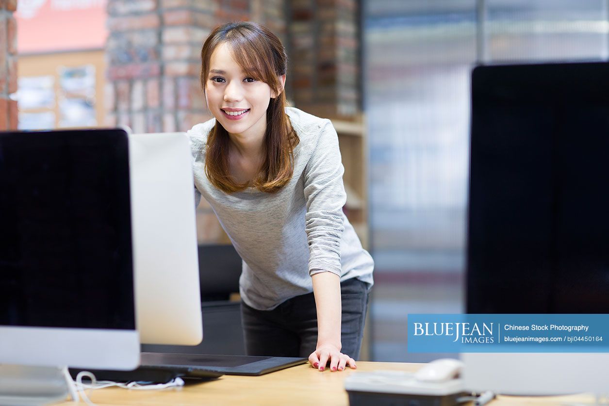 Young Chinese woman using computer in office-High-res stock photo for ...