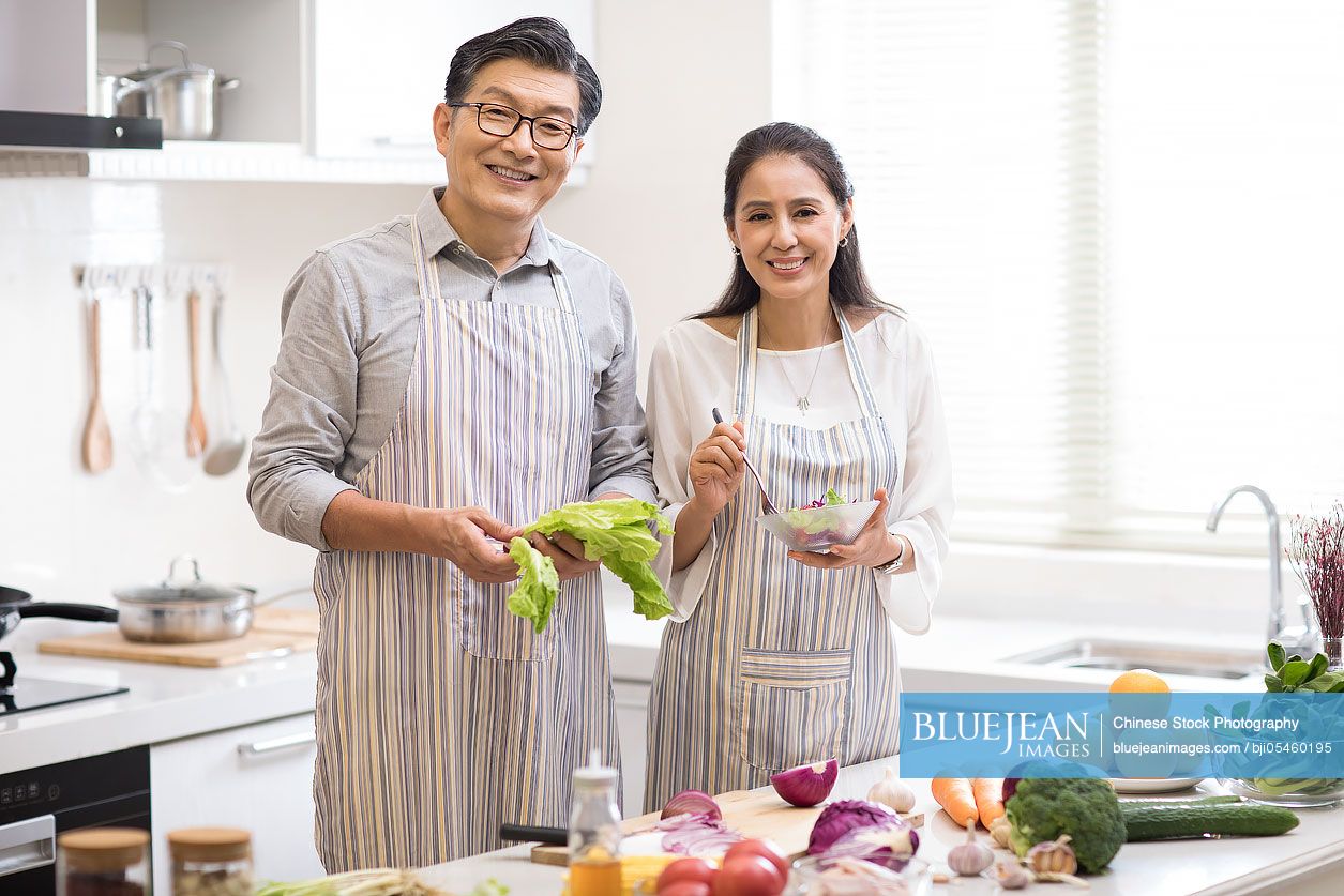 Happy mature Chinese couple cooking in kitchen-High-res stock photo for ...