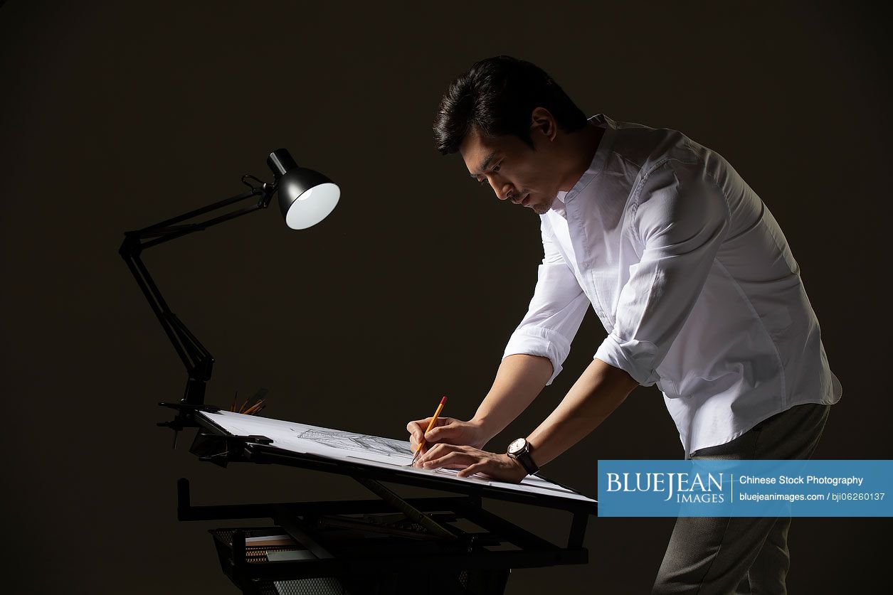 Chinese designer working on construction plan-High-res stock photo for ...