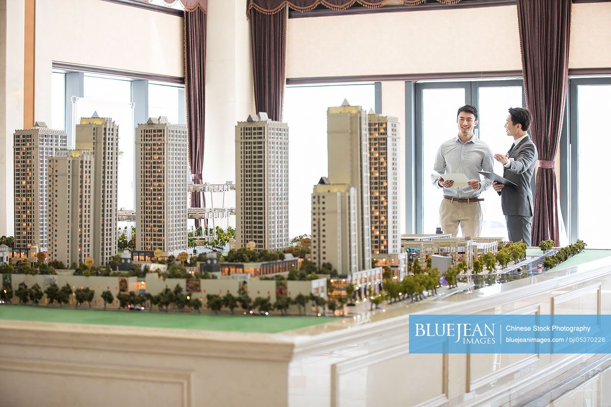 Chinese realtor showing architectural model to young man-High-res stock ...