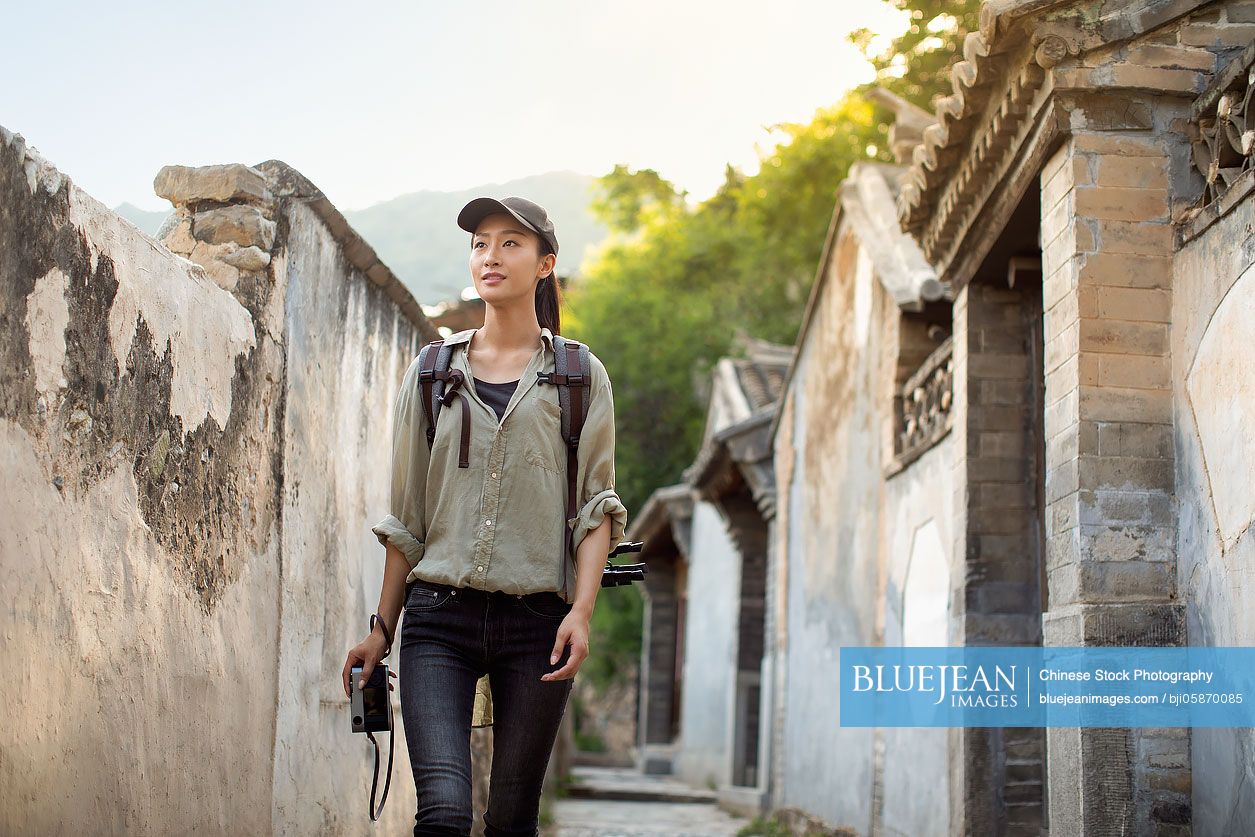 Chinese photographer walking in village-High-res stock photo for download