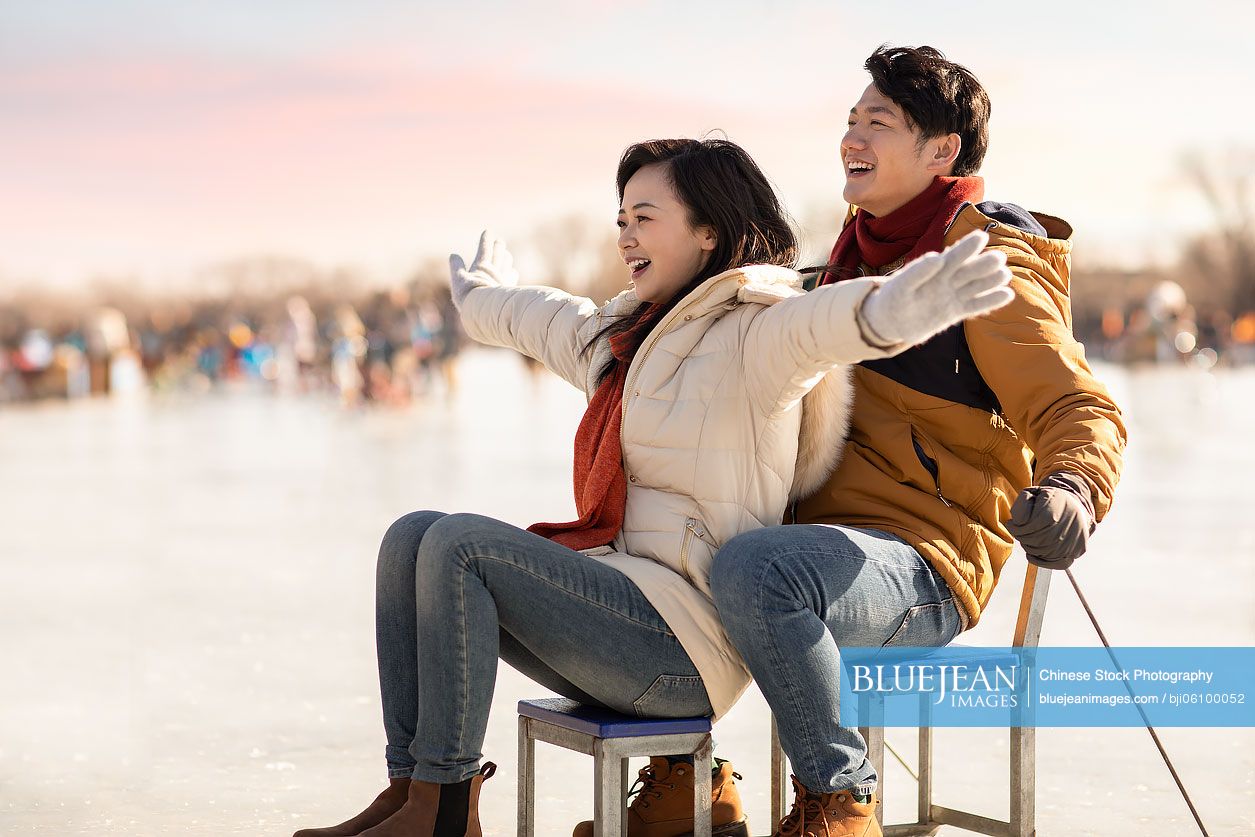 Happy young Chinese couple playing on ice-High-res stock photo for download