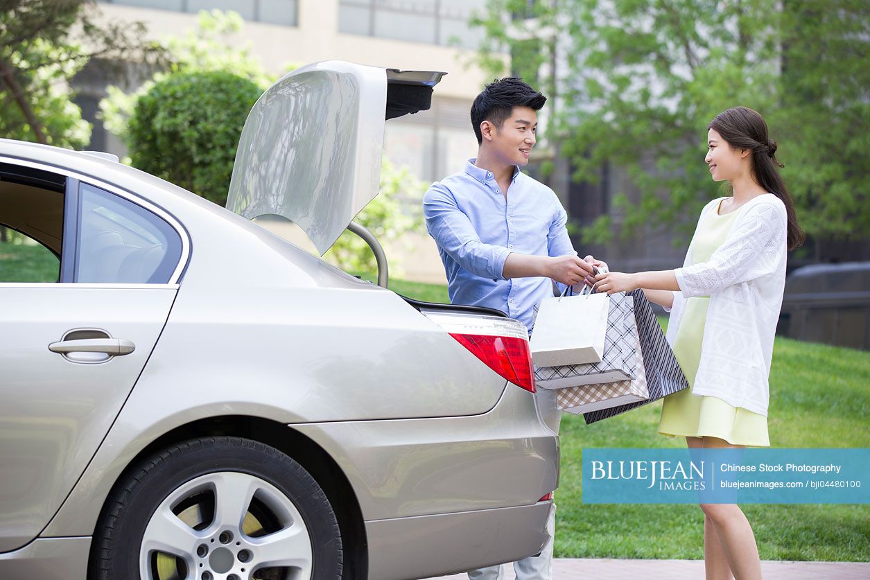 Young Chinese couple coming back from shopping-High-res stock photo for download