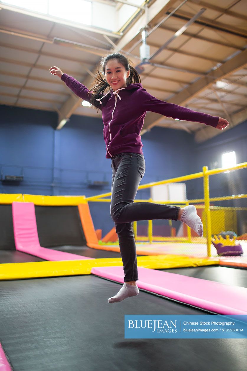 Happy young Chinese woman jumping on trampoline-High-res stock photo ...