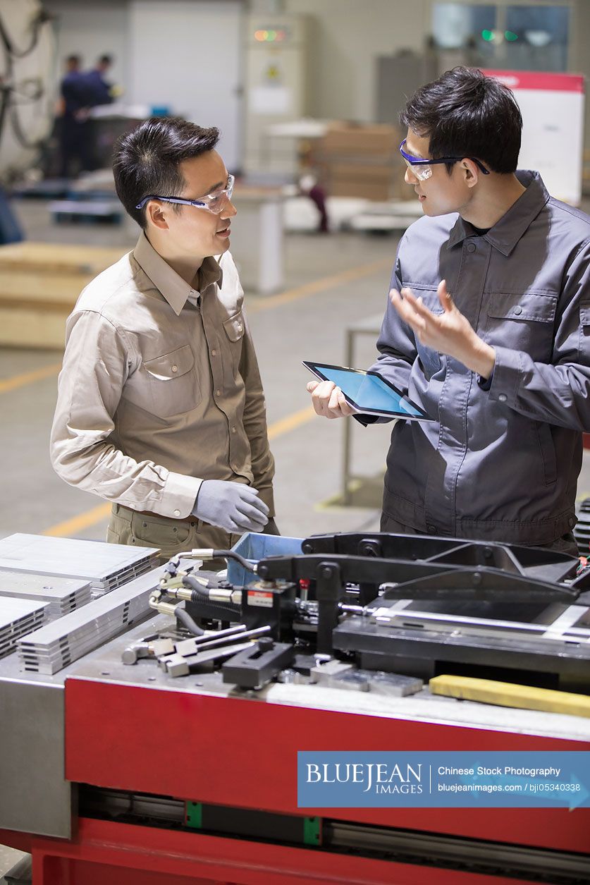 Confident Chinese engineers talking in the factory-High-res stock photo ...