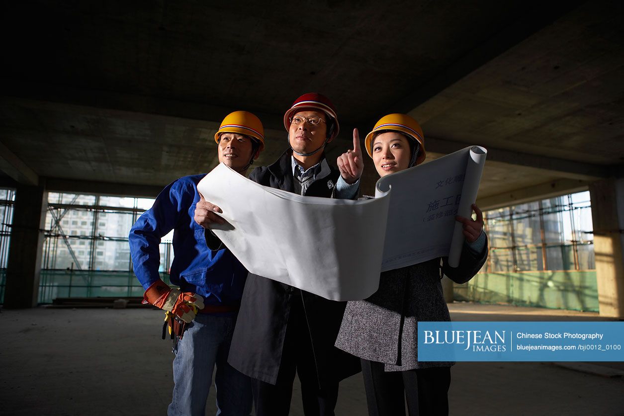 Chinese businesspeople in construction site wearing hard hats-High-res ...