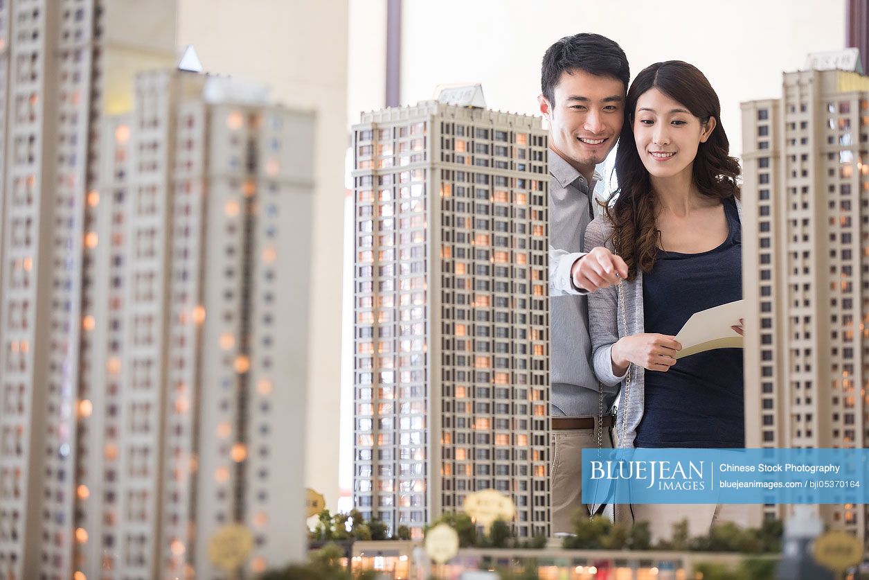 Happy young Chinese couple buying new house from sales center-High-res ...