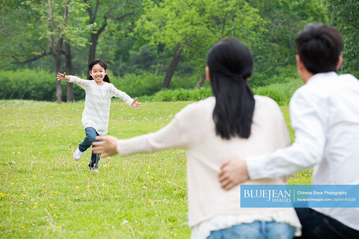 Happy Chinese girl running to hug her parents-High-res stock photo for ...