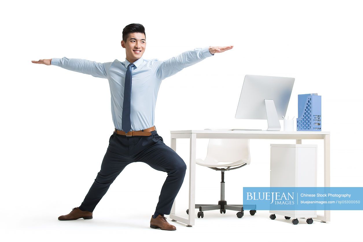 Young Chinese businessman exercising in office-High-res stock photo for ...