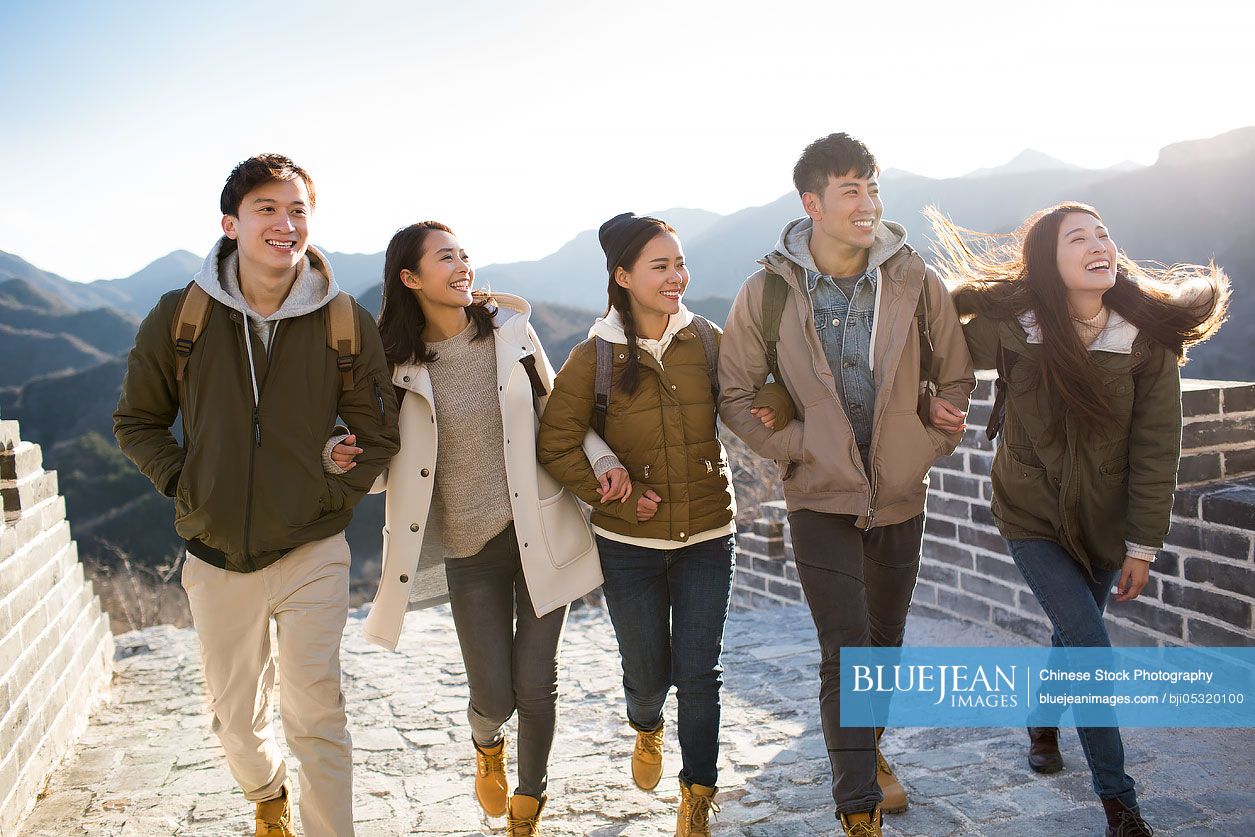 Happy young Chinese friends enjoying winter outing on the Great Wall ...