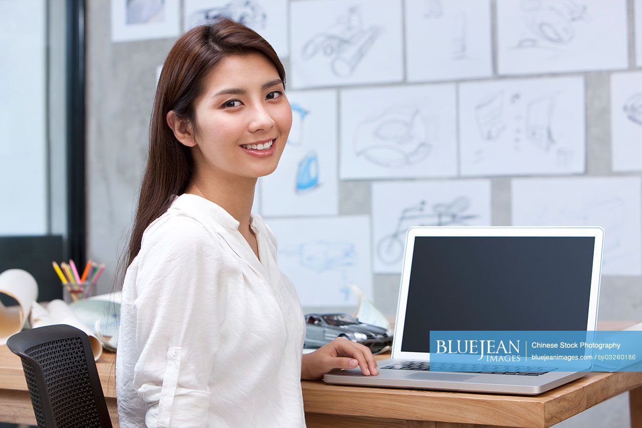 Chinese designer sitting before laptop in studio-High-res stock photo ...