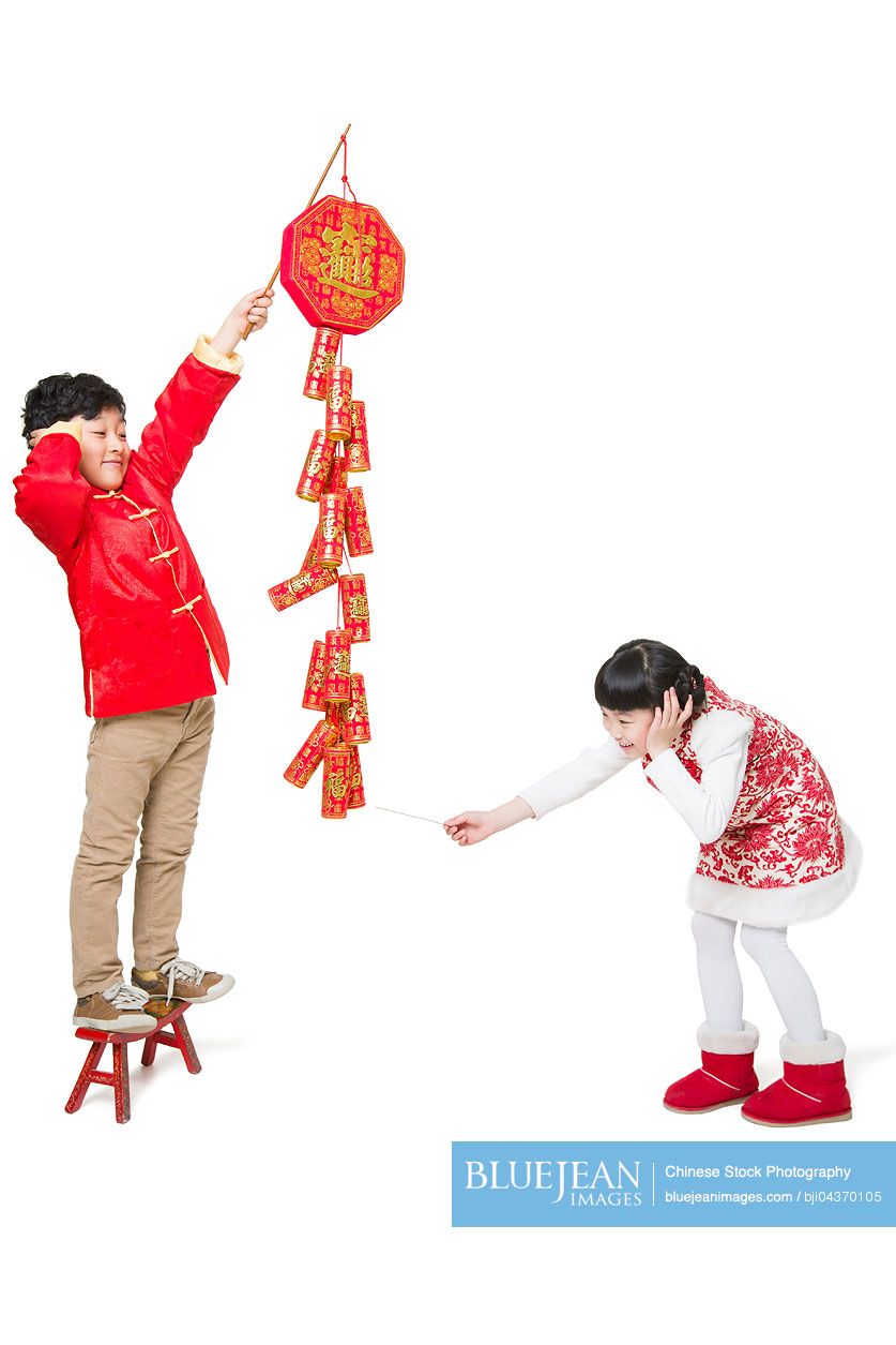 Happy children celebrating Chinese new year with petard-High-res stock photo for download