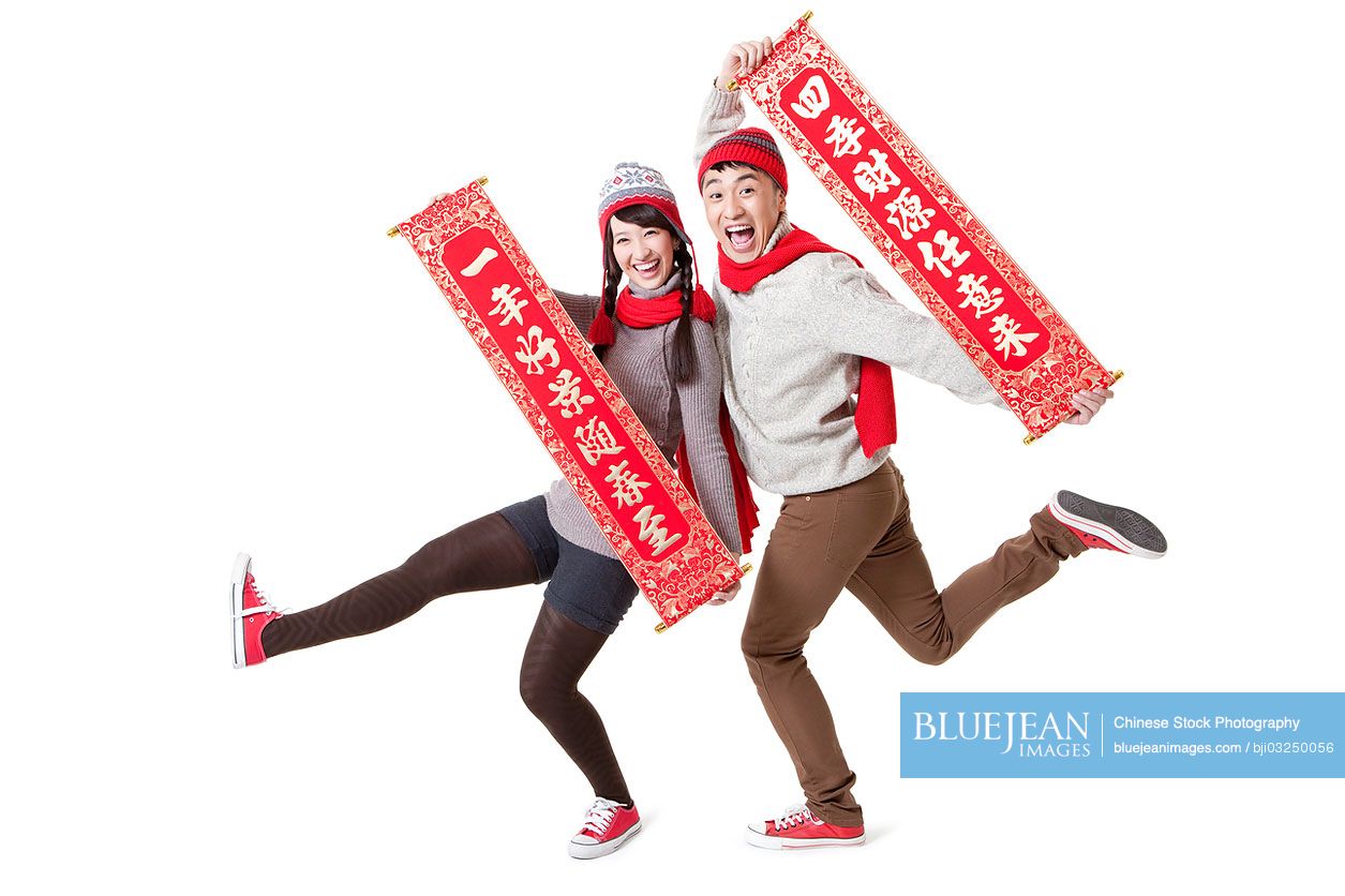 Cute young couple celebrating Chinese New Year with couplets-High-res ...