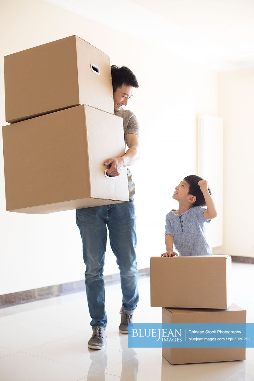 Happy young Chinese father and son moving home-High-res stock photo for ...