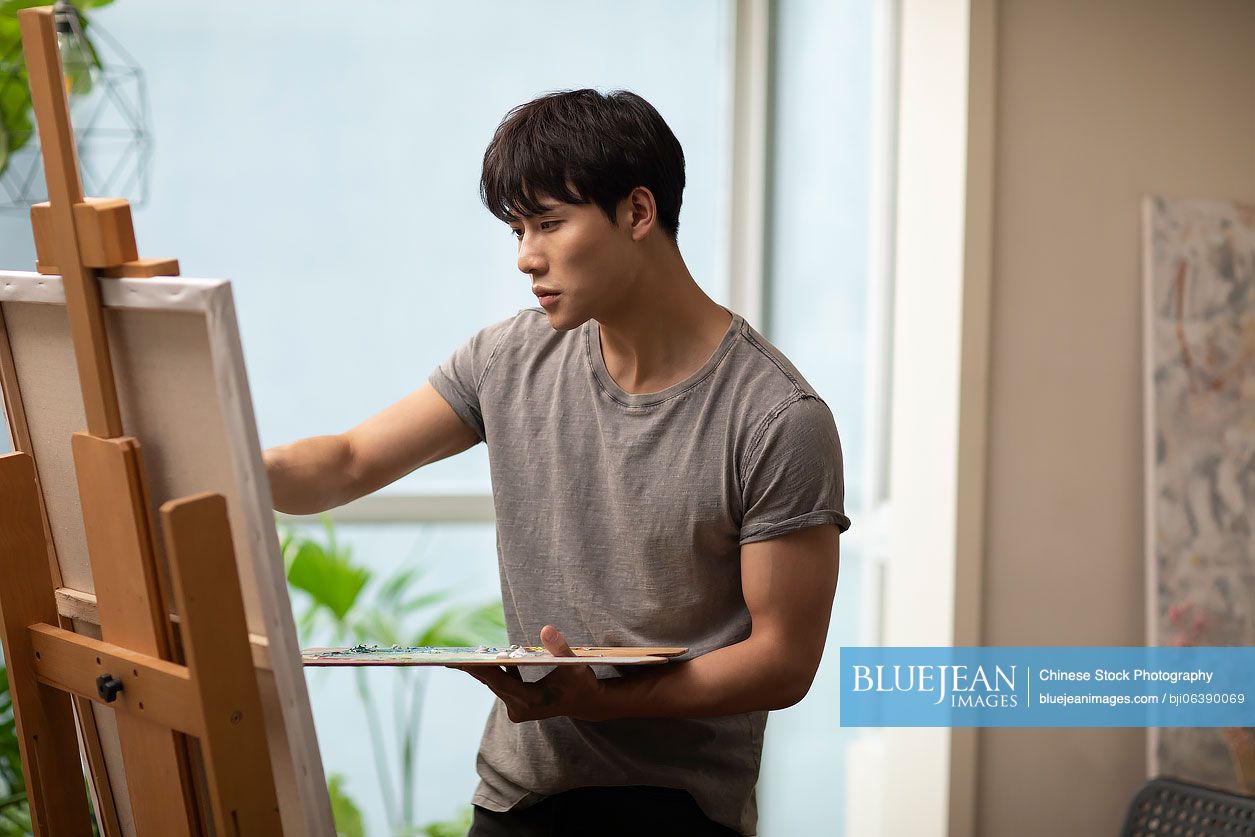 Young Chinese man painting at home-High-res stock photo for download