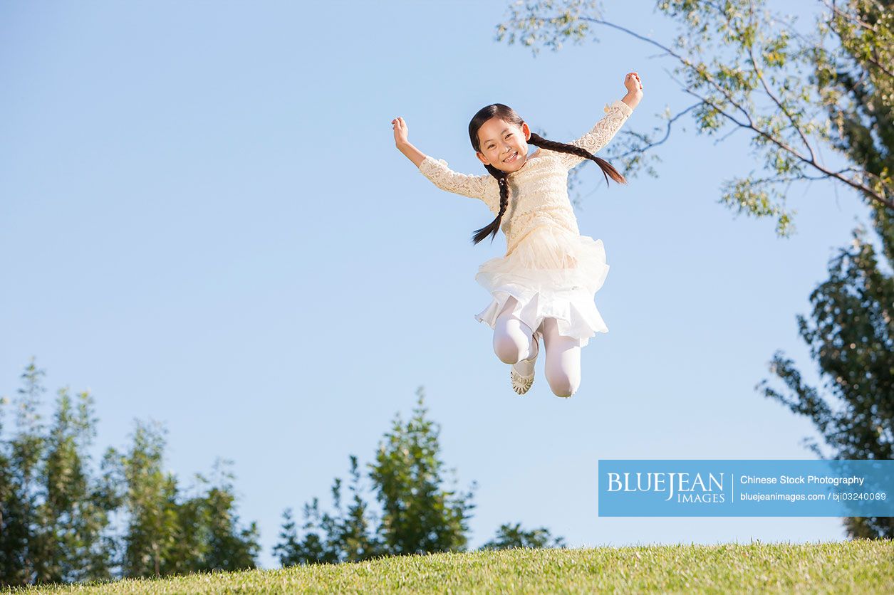 Chinese Little Girl Jumping Excitedly In A Park High res Stock Photo Chinese Little Girl Jumping Excitedly In A Park High res Stock Photo