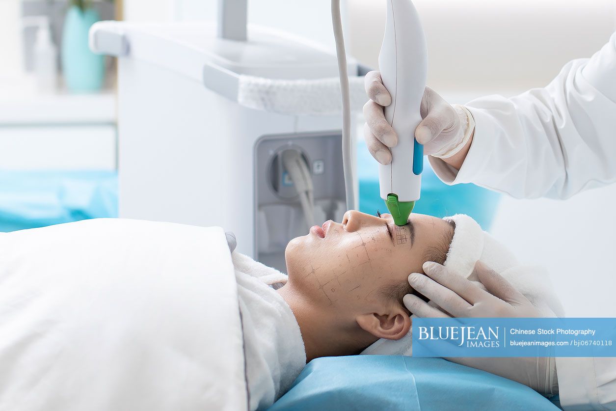Young Chinese woman receiving beauty treatment in hospital-High-res stock photo for download