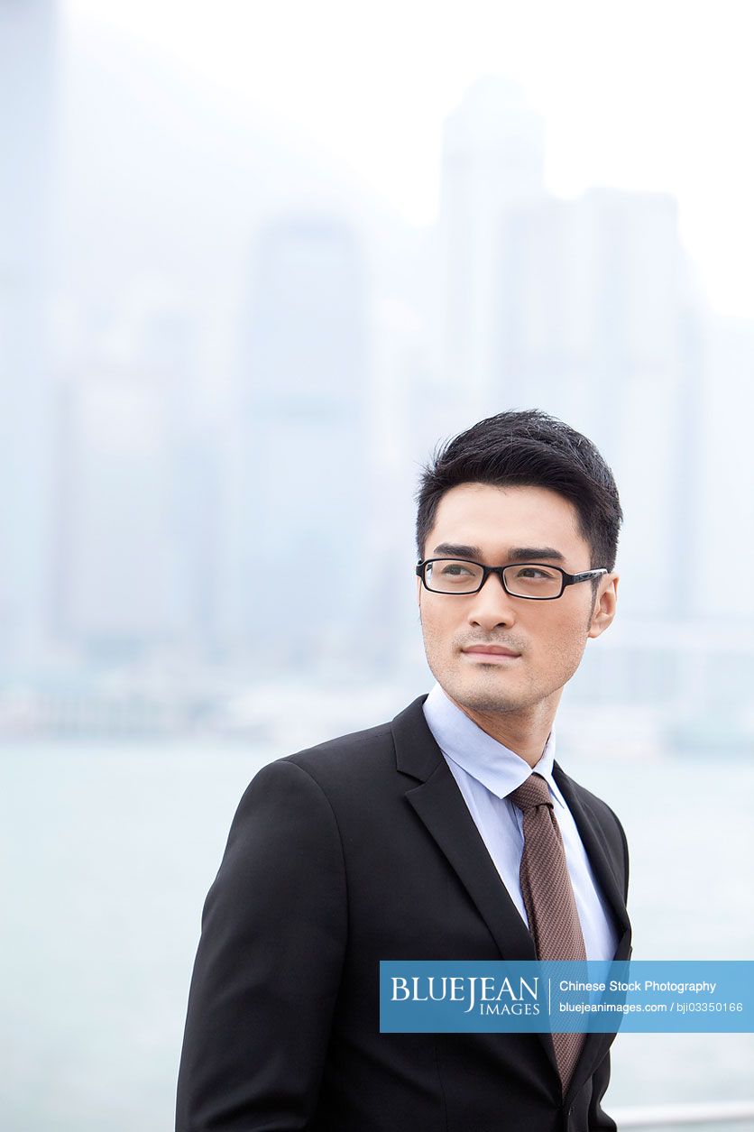 Professional Chinese businessman with glasses looking at view, Hong ...