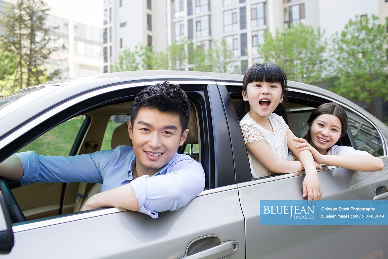 Happy young Chinese family in a car-High-res stock photo for download