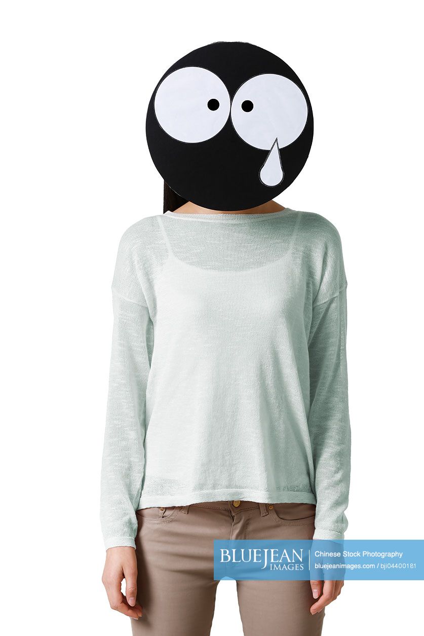 Young Chinese woman with a shocked emoticon face in front of her face ...