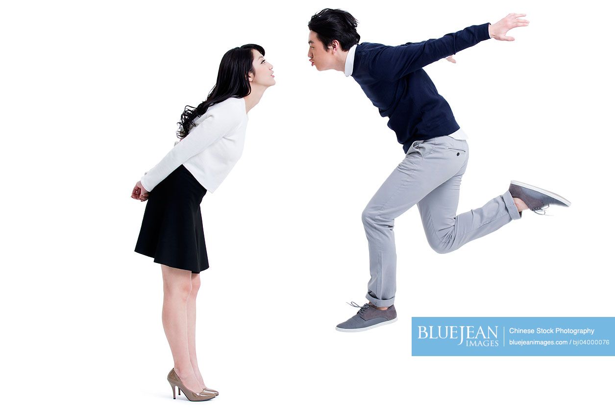 Cheerful young Chinese couple kissing-High-res stock photo for download