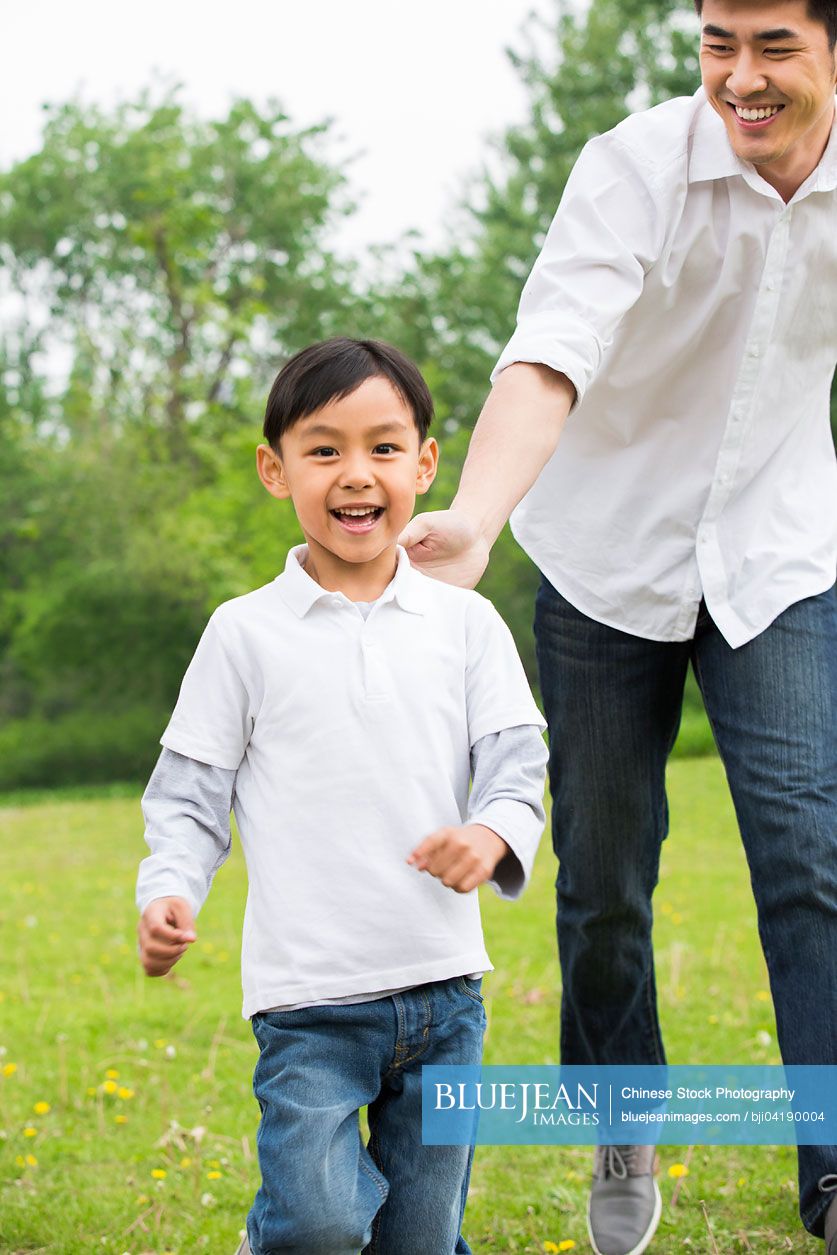 Happy Chinese father and son running on the grass-High-res stock photo ...