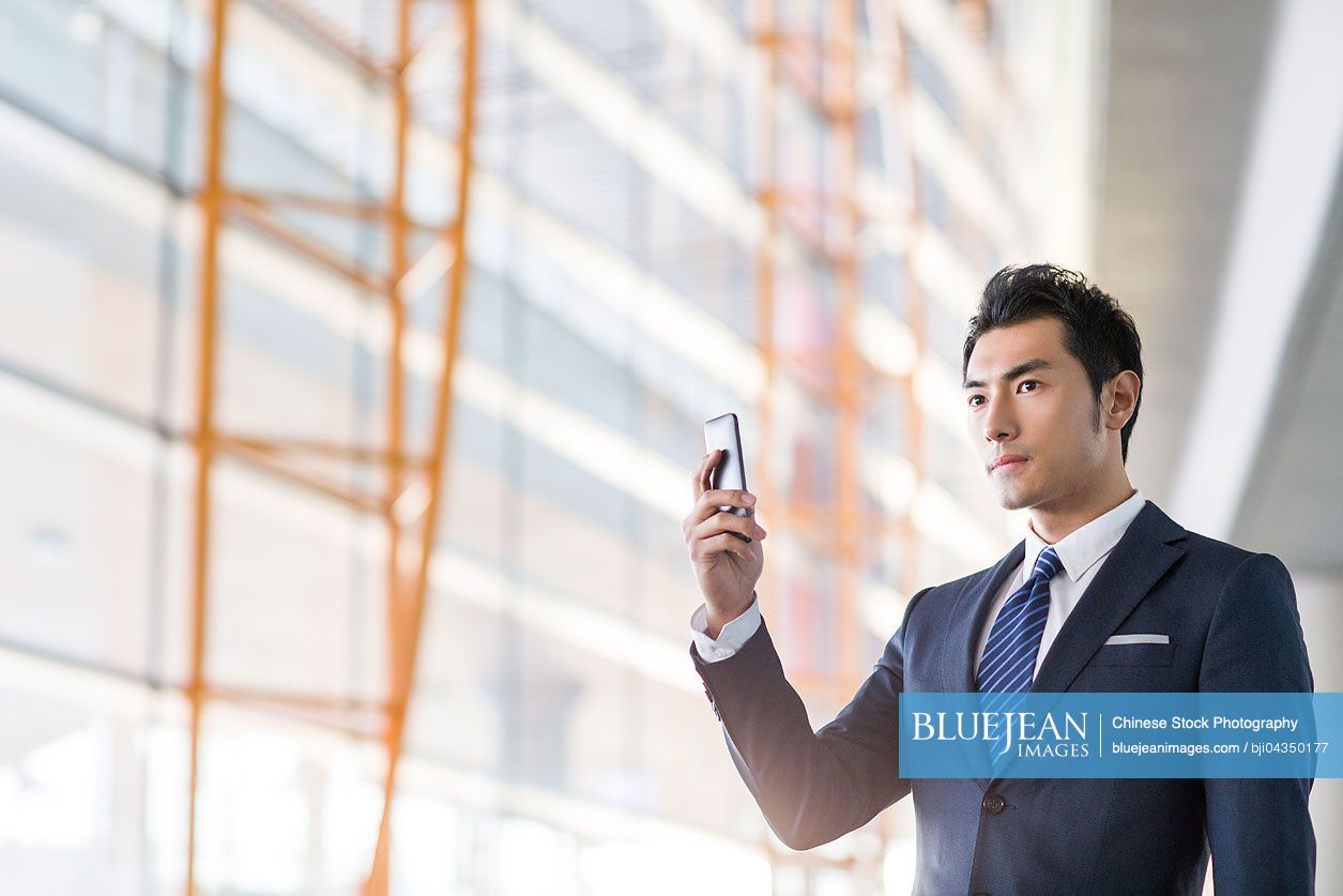 Young Chinese businessman using smart phone in airport-High-res stock ...