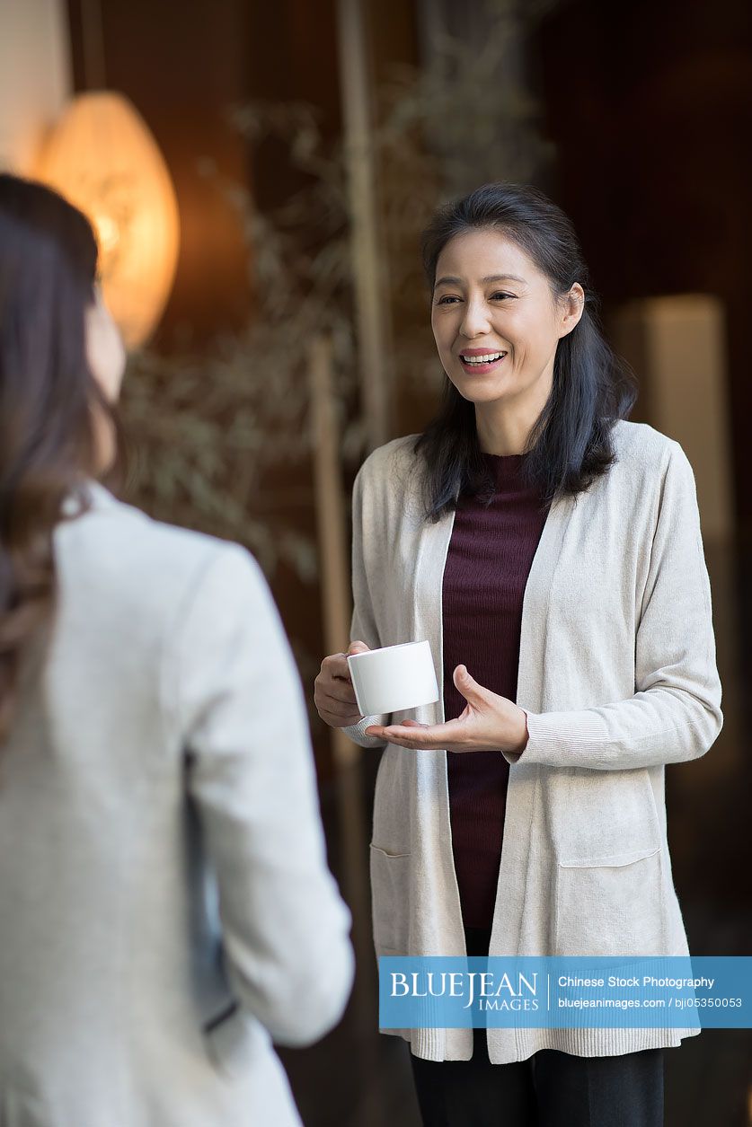 Elegant mature Chinese woman talking with young woman-High-res stock ...