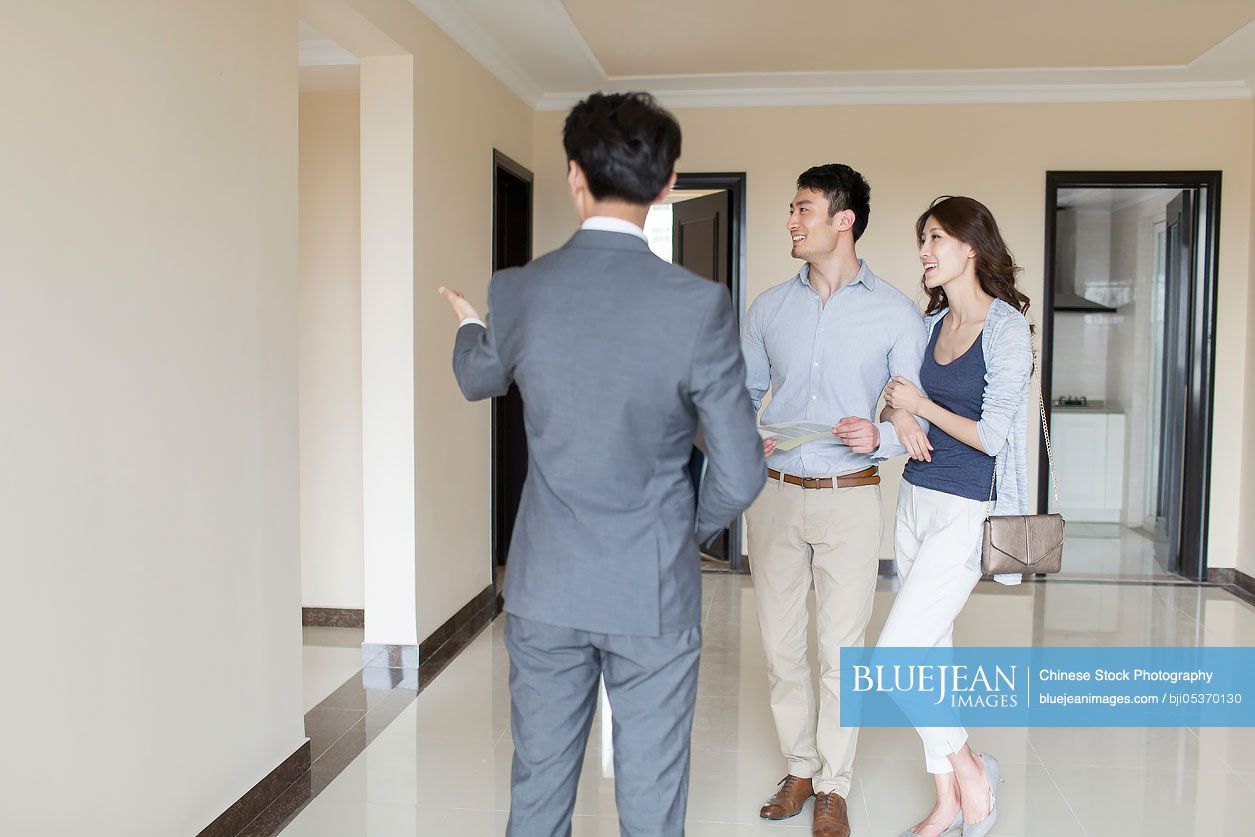 Chinese realtor showing new house to young couple-High-res stock photo ...