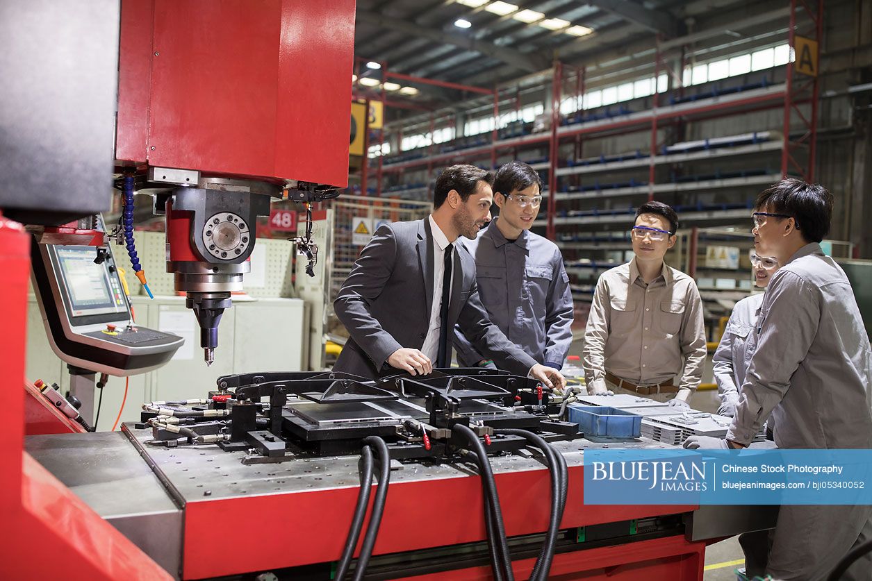 Businessman and engineers checking machine in the factory-High-res ...