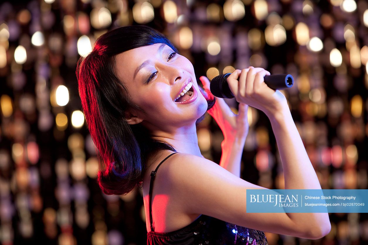 Young Chinese woman singing Karaoke-High-res stock photo for download