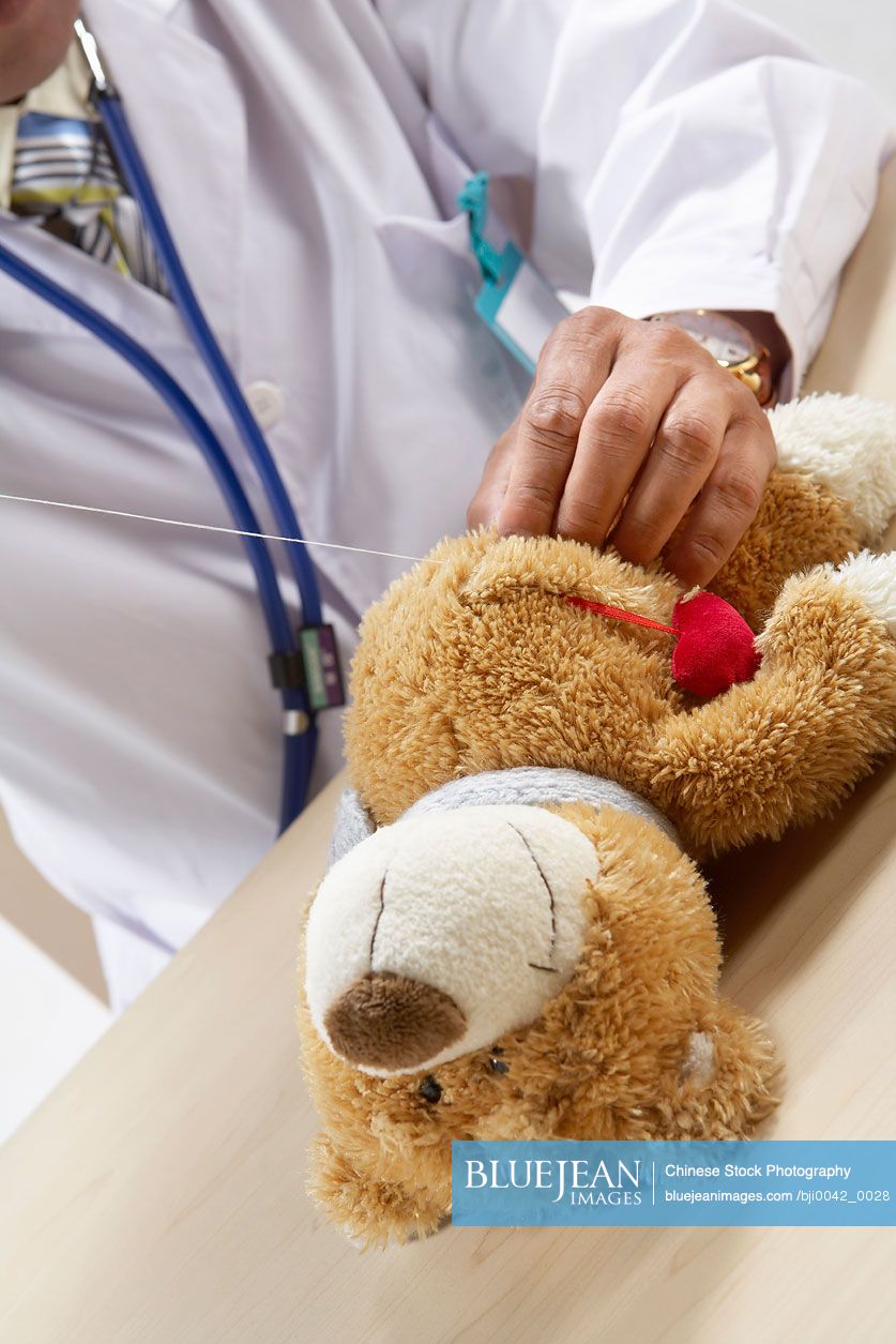 Chinese doctor listening to a teddy bear's heart beat-High-res stock ...