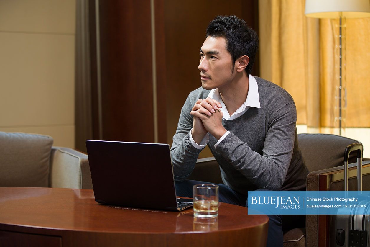 Young Chinese businessman thinking in hotel room-High-res stock photo ...