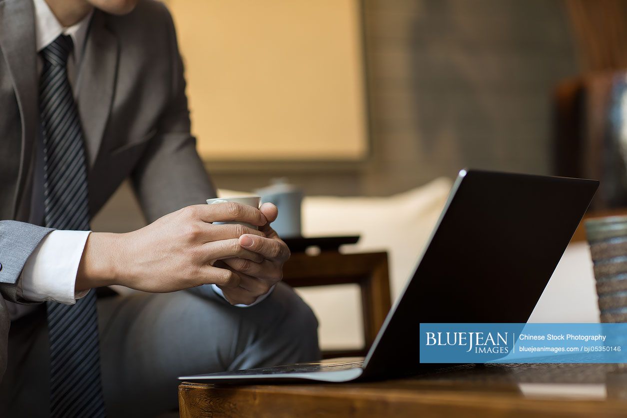 Confident Chinese businessman using laptop-High-res stock photo for download