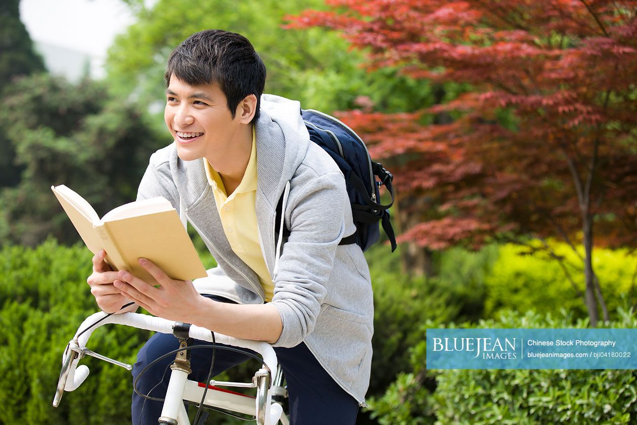 Male Chinese college student reading a book-High-res stock photo for ...