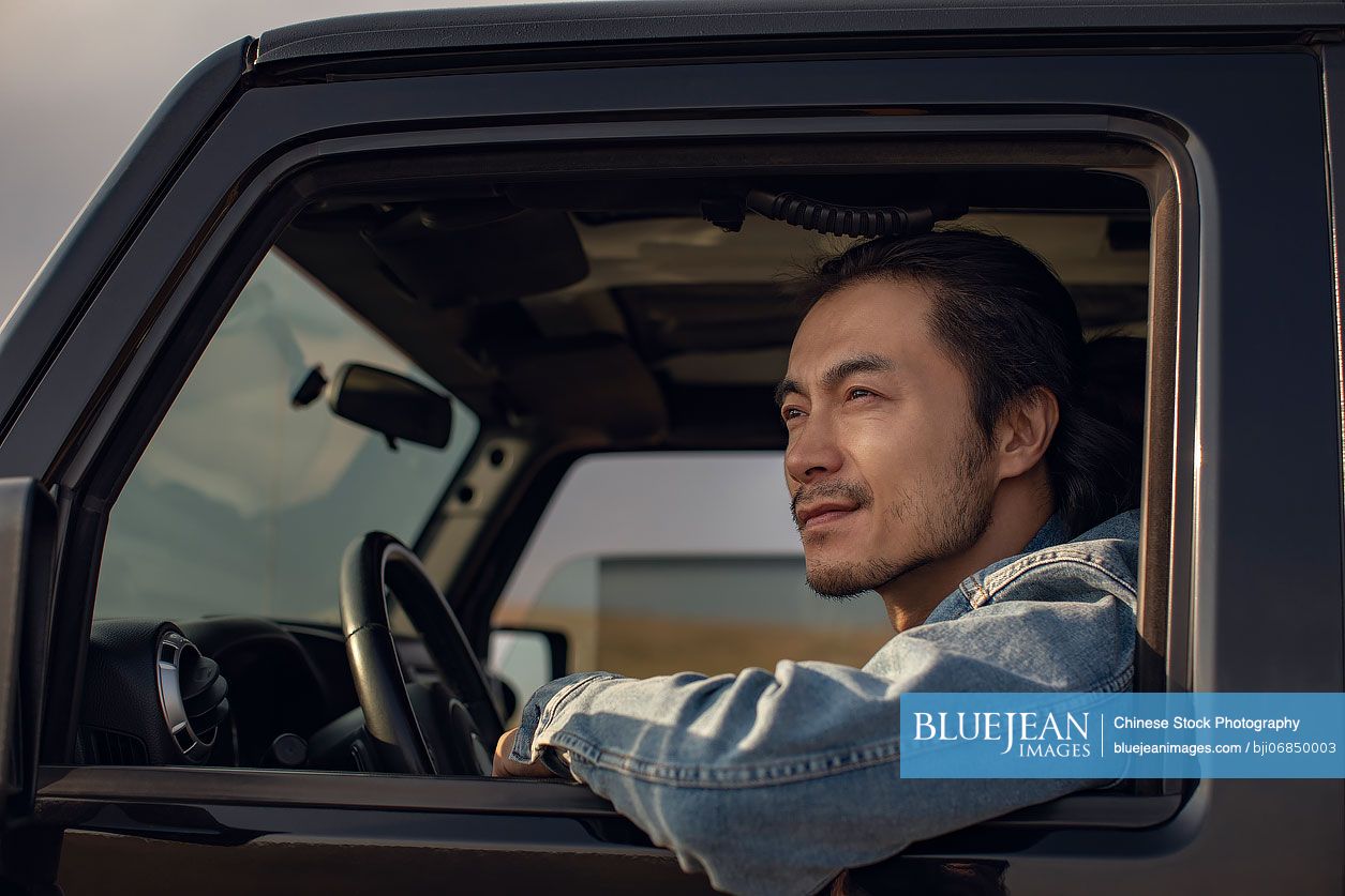 Happy Chinese mid adult man enjoying road trip-High-res stock photo for download