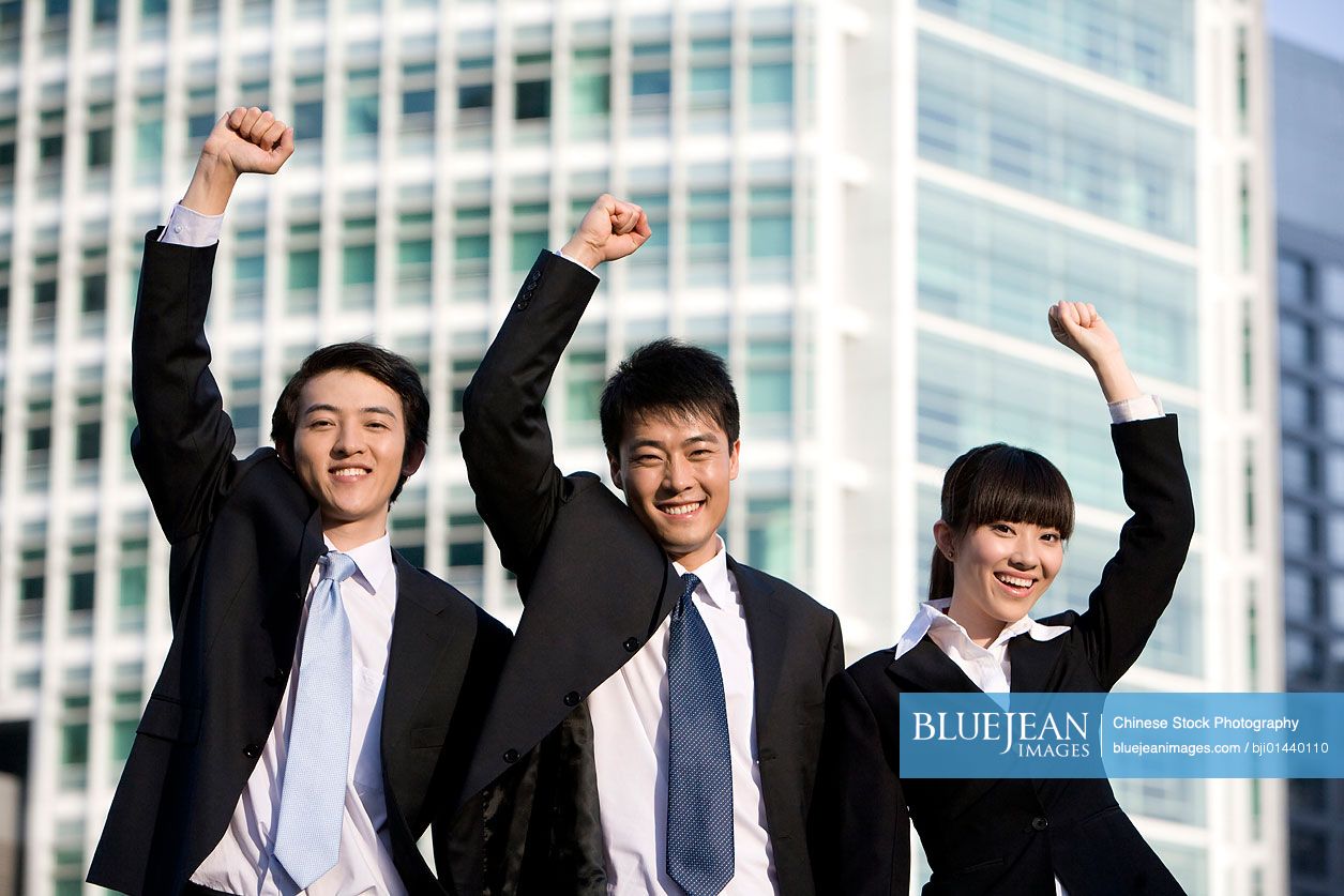 Three Chinese business professionals in front of skyscraper-High-res ...