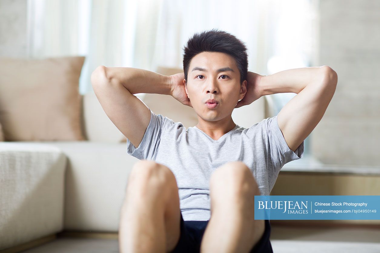Young Chinese man exercising at home-High-res stock photo for download