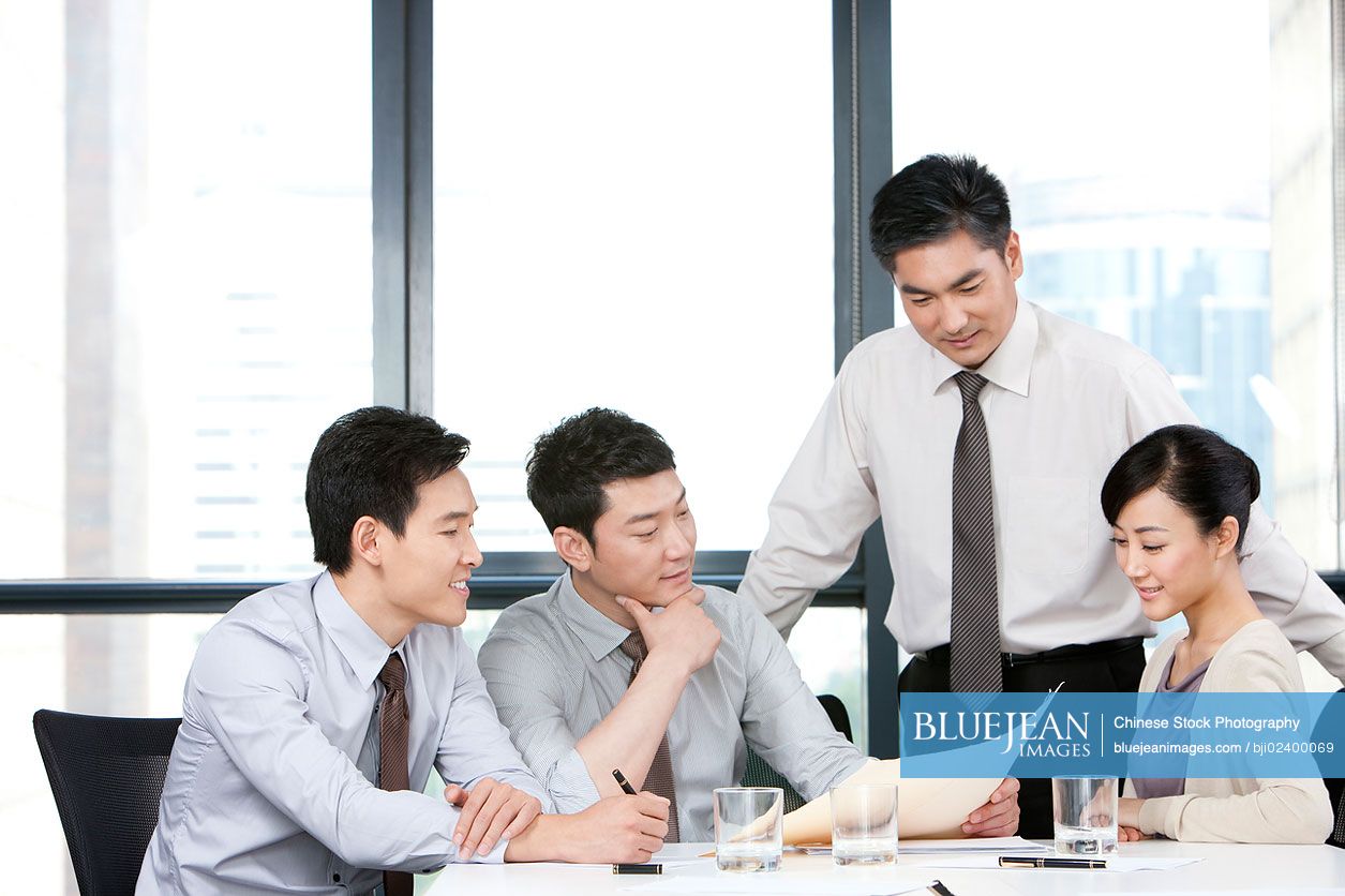 Chinese business executive going over business team's ideas-High-res ...