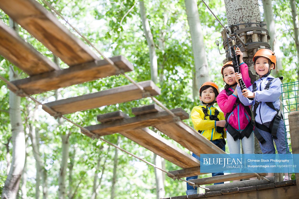 Happy Chinese children playing in tree top adventure park-High-res ...