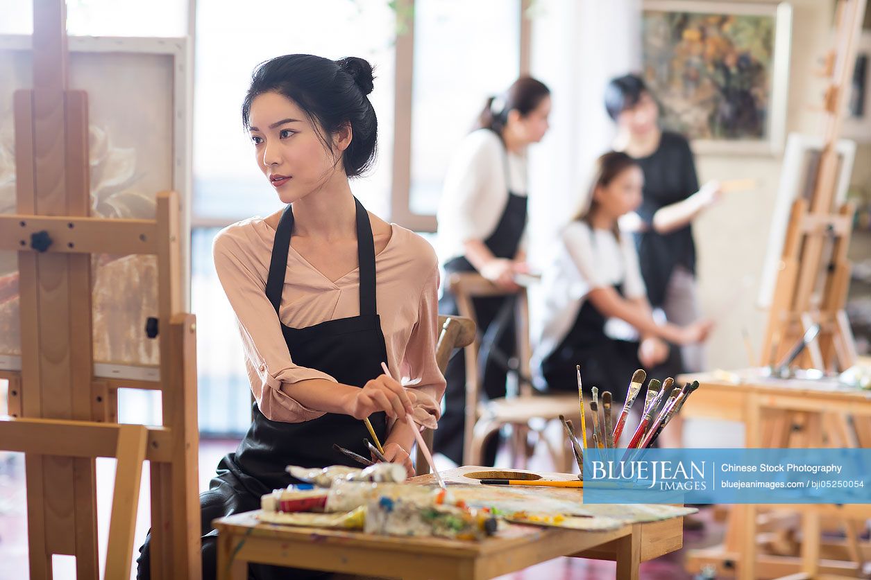 Young Chinese woman painting in art class-High-res stock photo for download