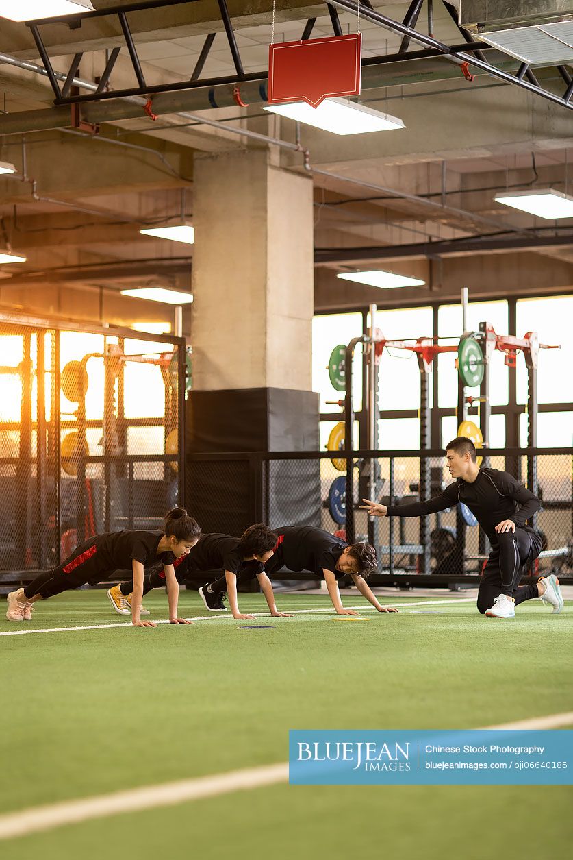 Active Chinese children having exercise class with their coach in gym-High-res stock photo for ...