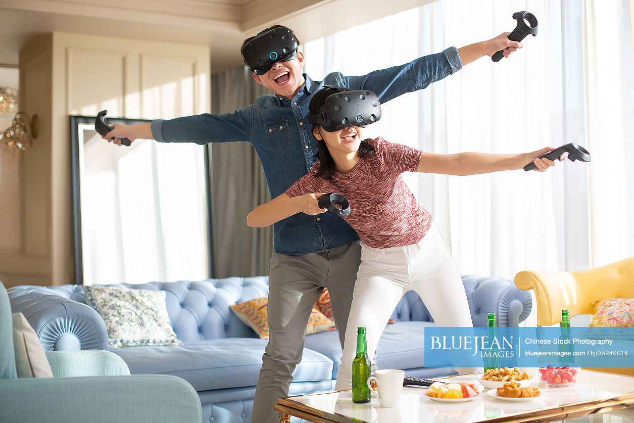 Young Chinese couple playing VR game-High-res stock photo for download