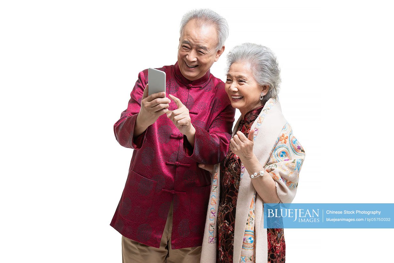 Happy senior Chinese couple using smartphone-High-res stock photo for download