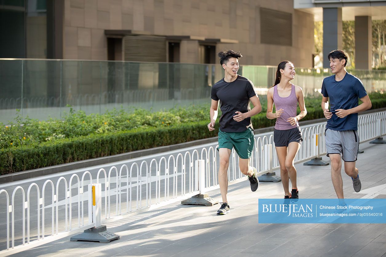 Young Chinese friends running outdoors-High-res stock photo for download