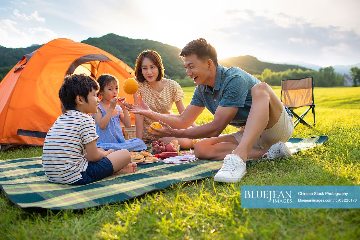 Happy young Chinese family having a picnic outdoors-High-res stock photo for download