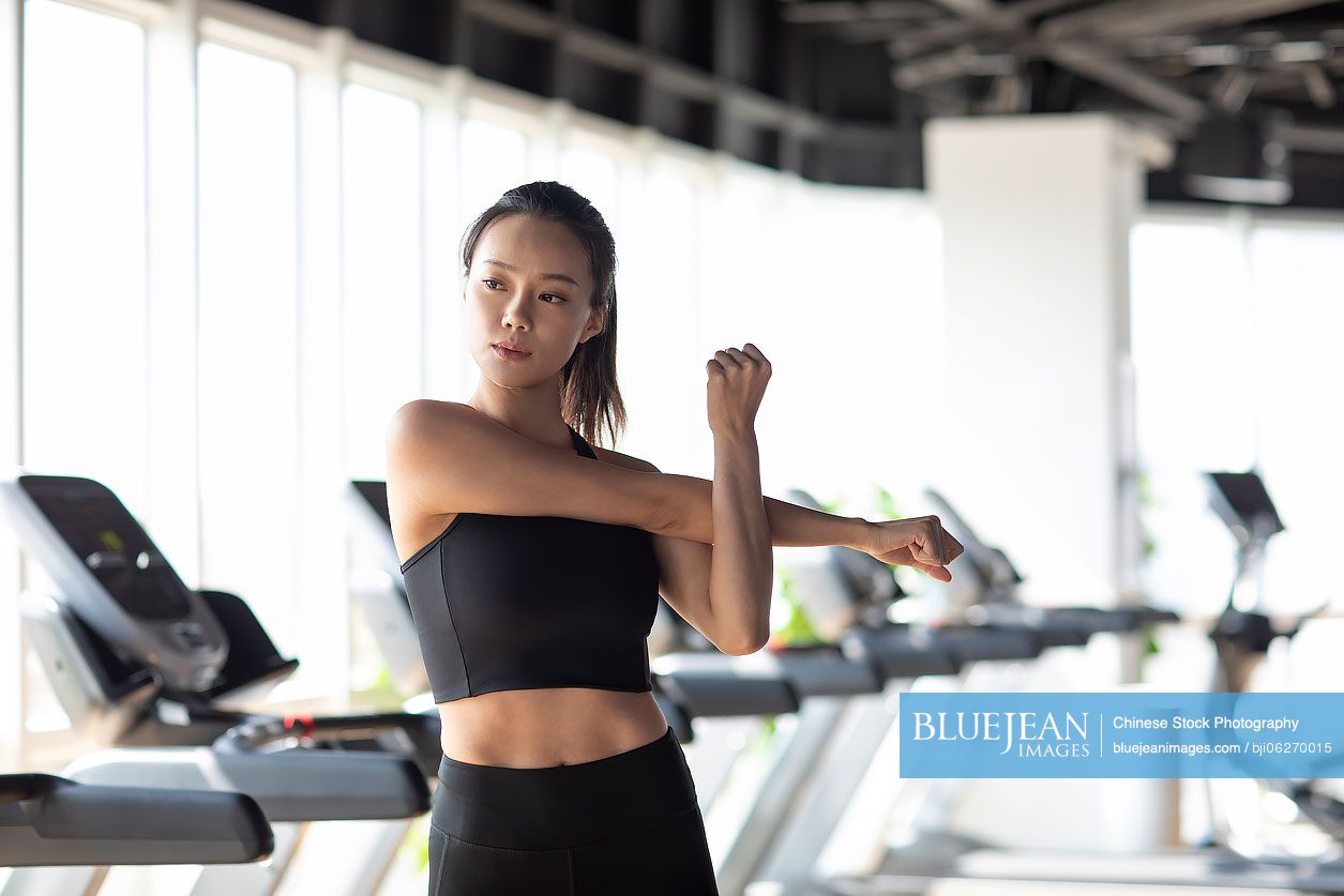 Young Chinese woman stretching at gym-High-res stock photo for download