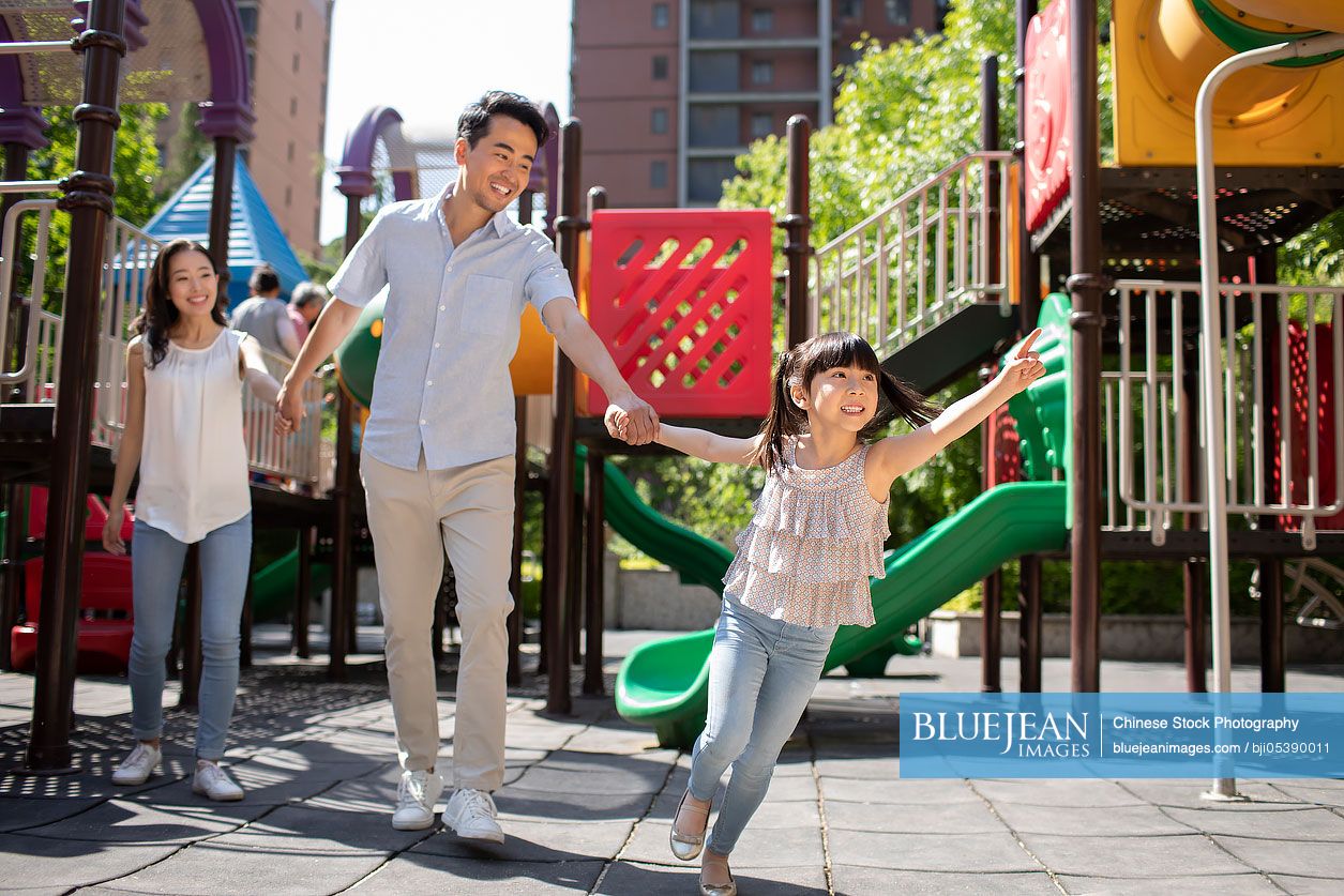 Happy young Chinese family playing in amusement park-High-res stock photo for download